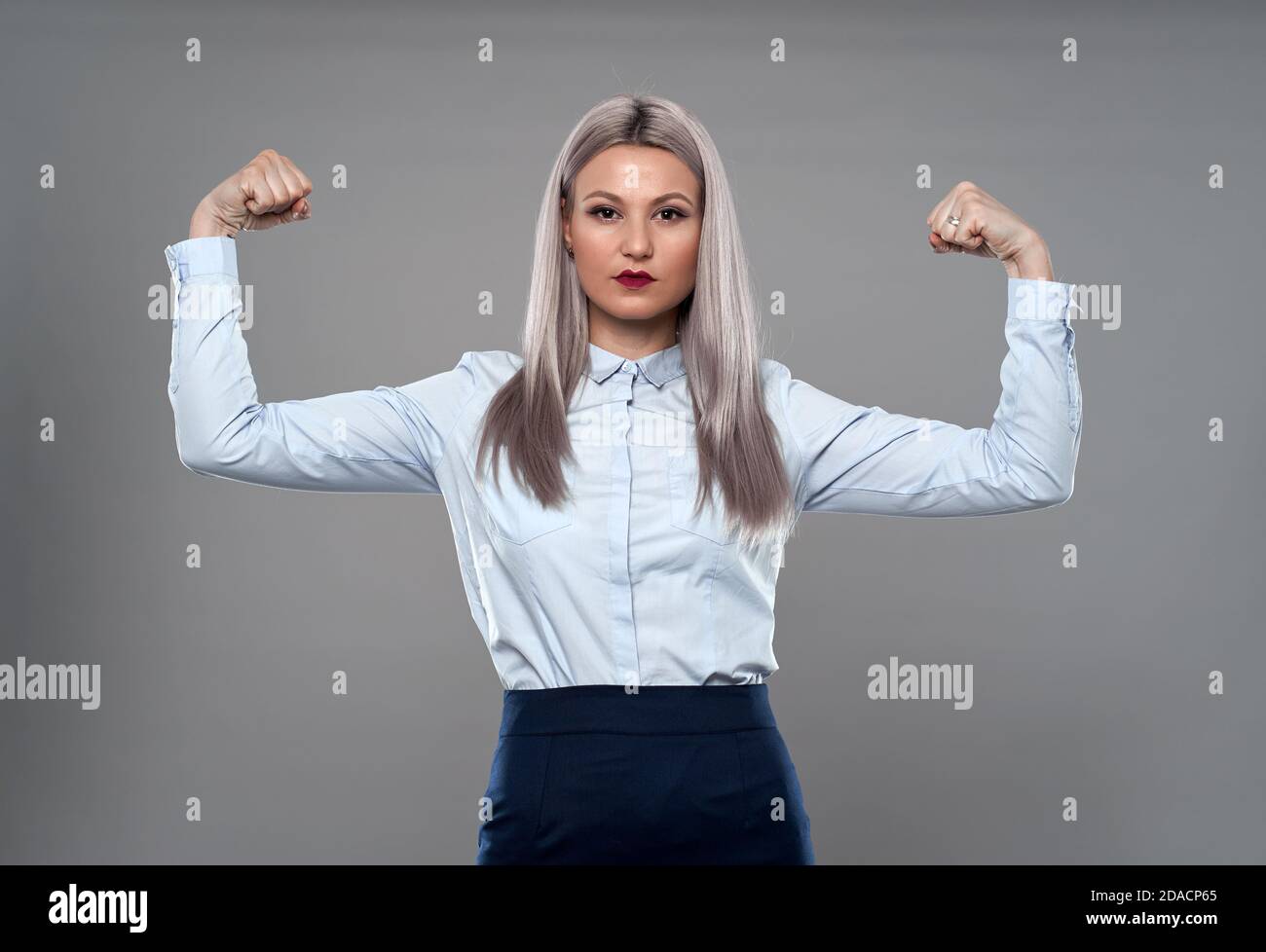Strong young businesswoman flexing her muscles in formal clothing Stock ...
