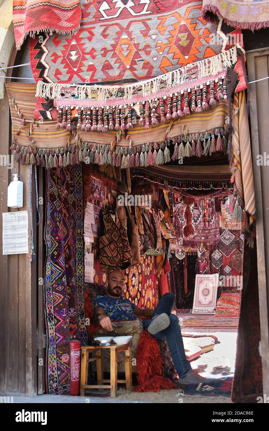 Carpets and rugs store owner sitting down and smoking in the store ...