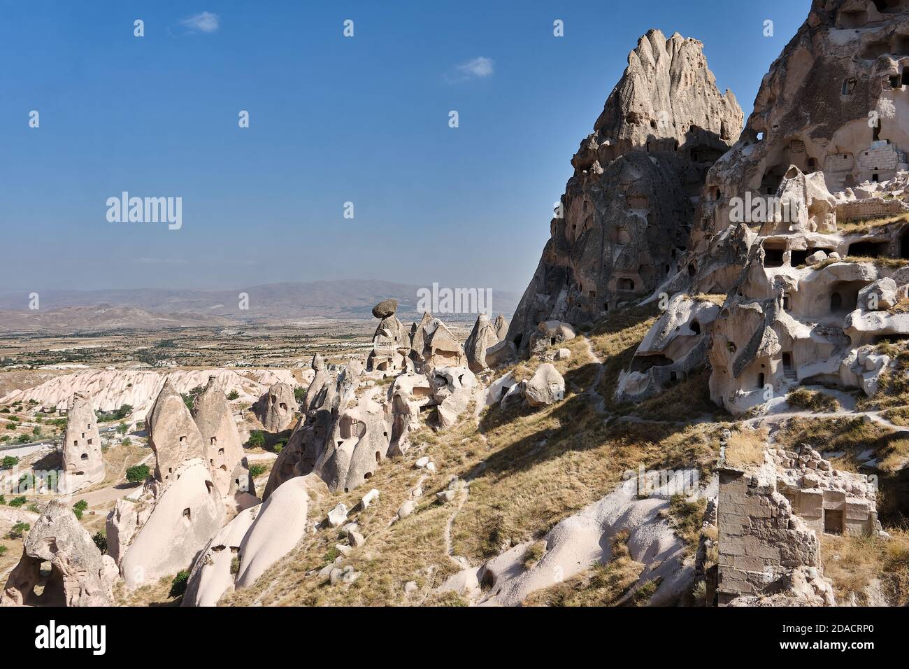 View of fairy chimney rock formations at the base of Uchisar Castle ...