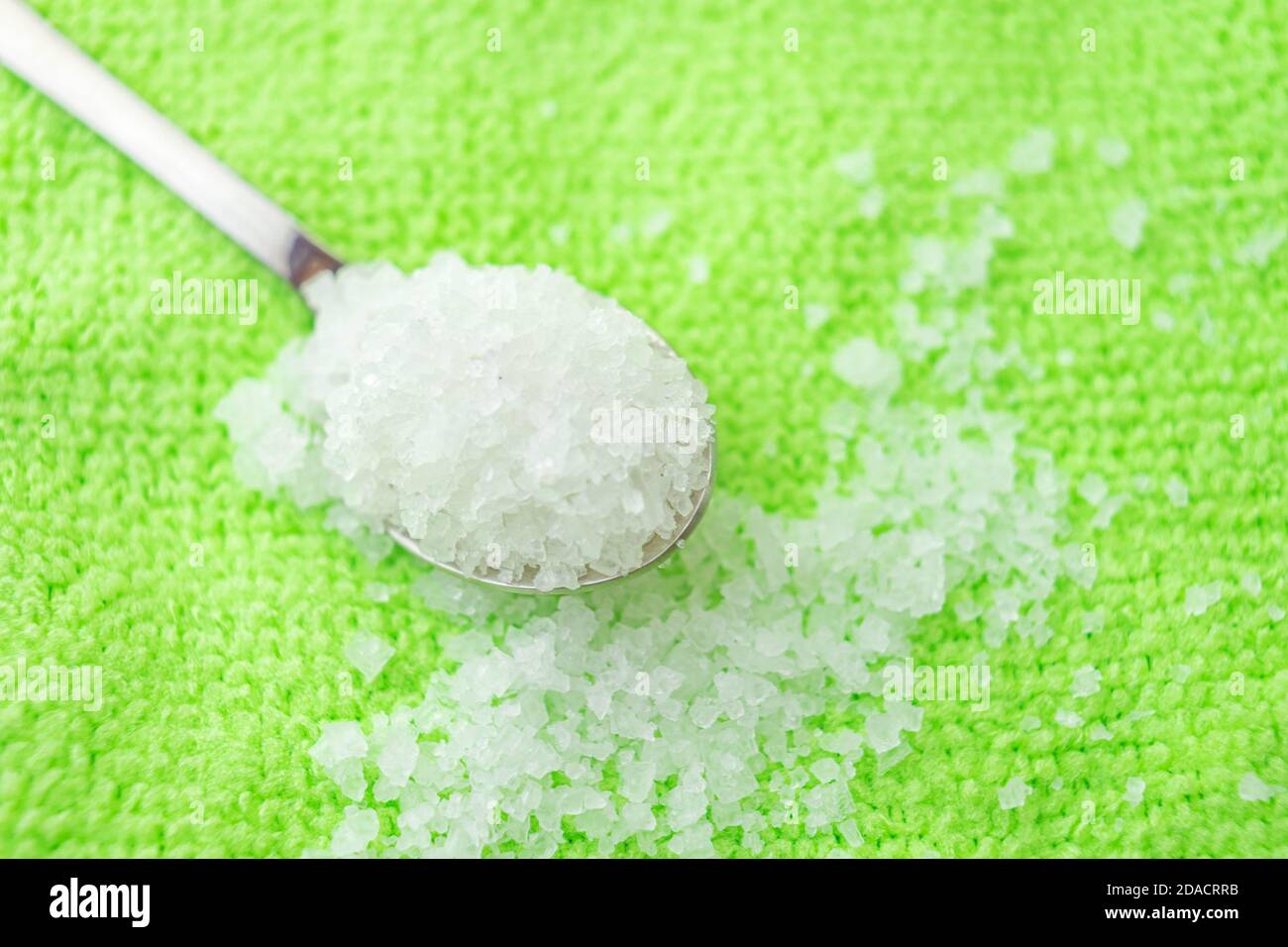 White sea salt in spoon on the lime green towel Stock Photo - Alamy