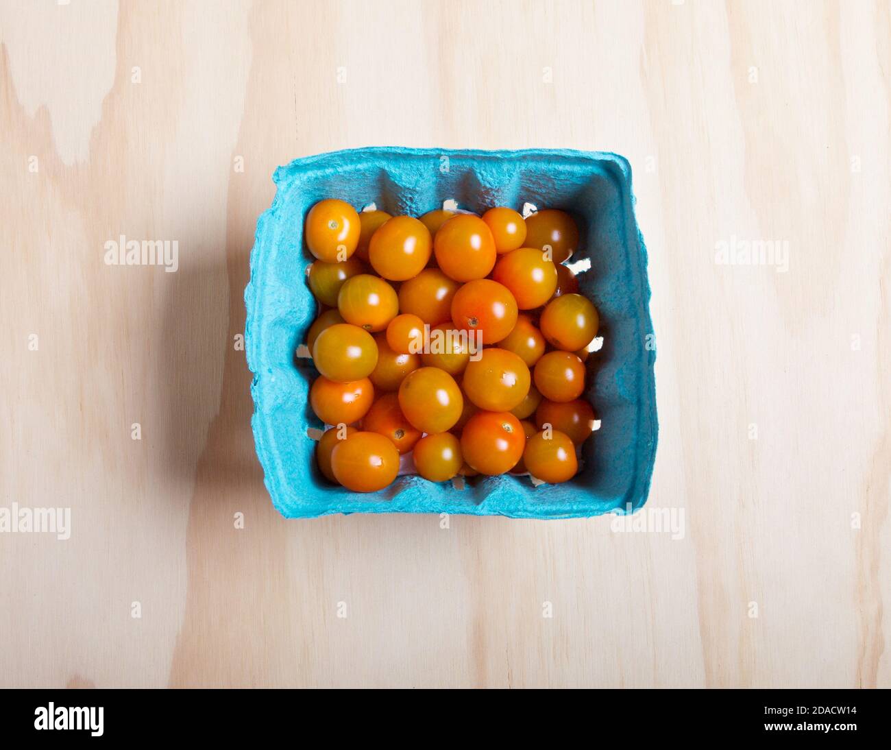 Dry pint of orange cherry tomatoes on wood table Stock Photo - Alamy