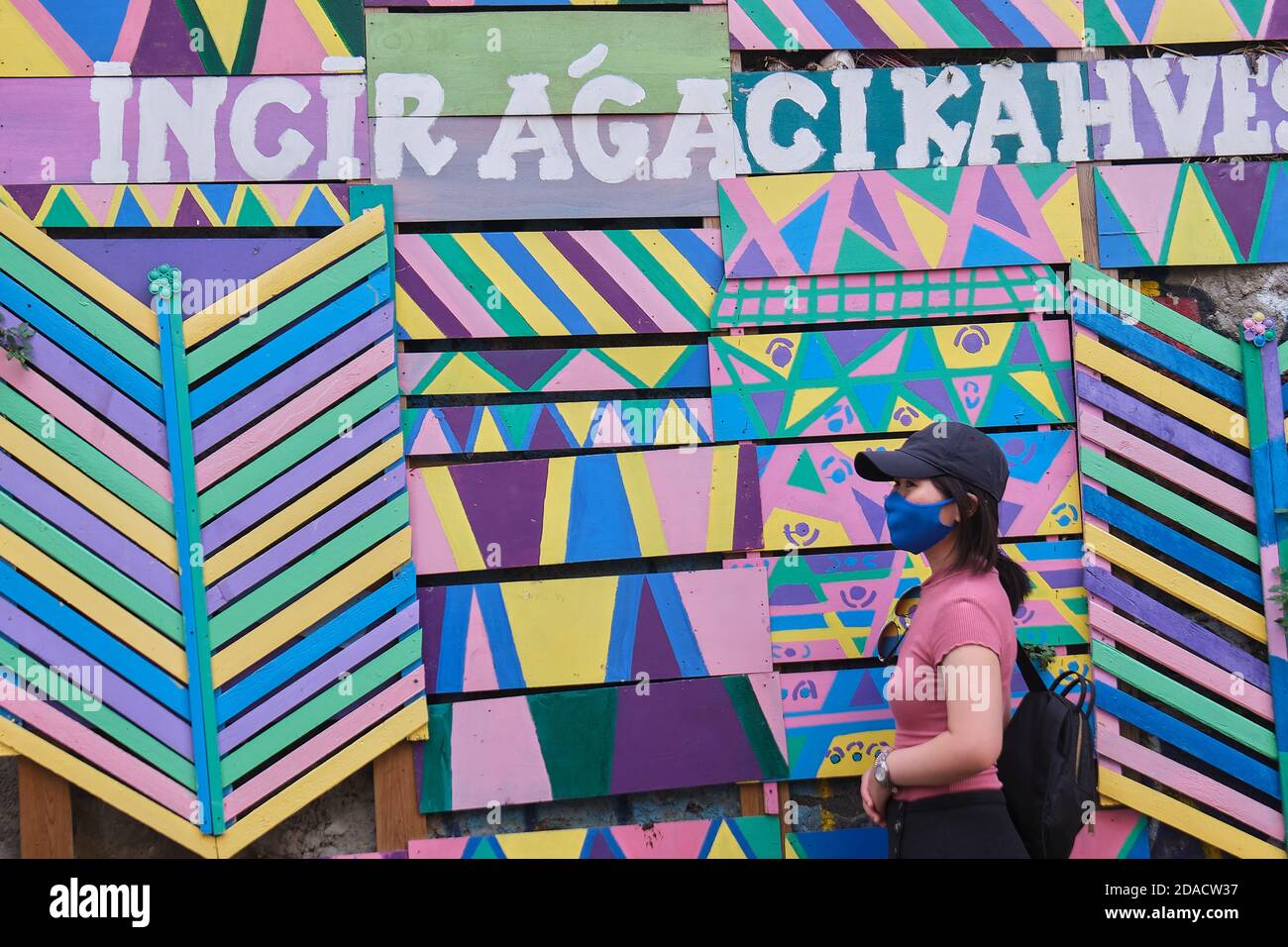 Tourist wearing a pink top and blue face mask blending into the multi ...