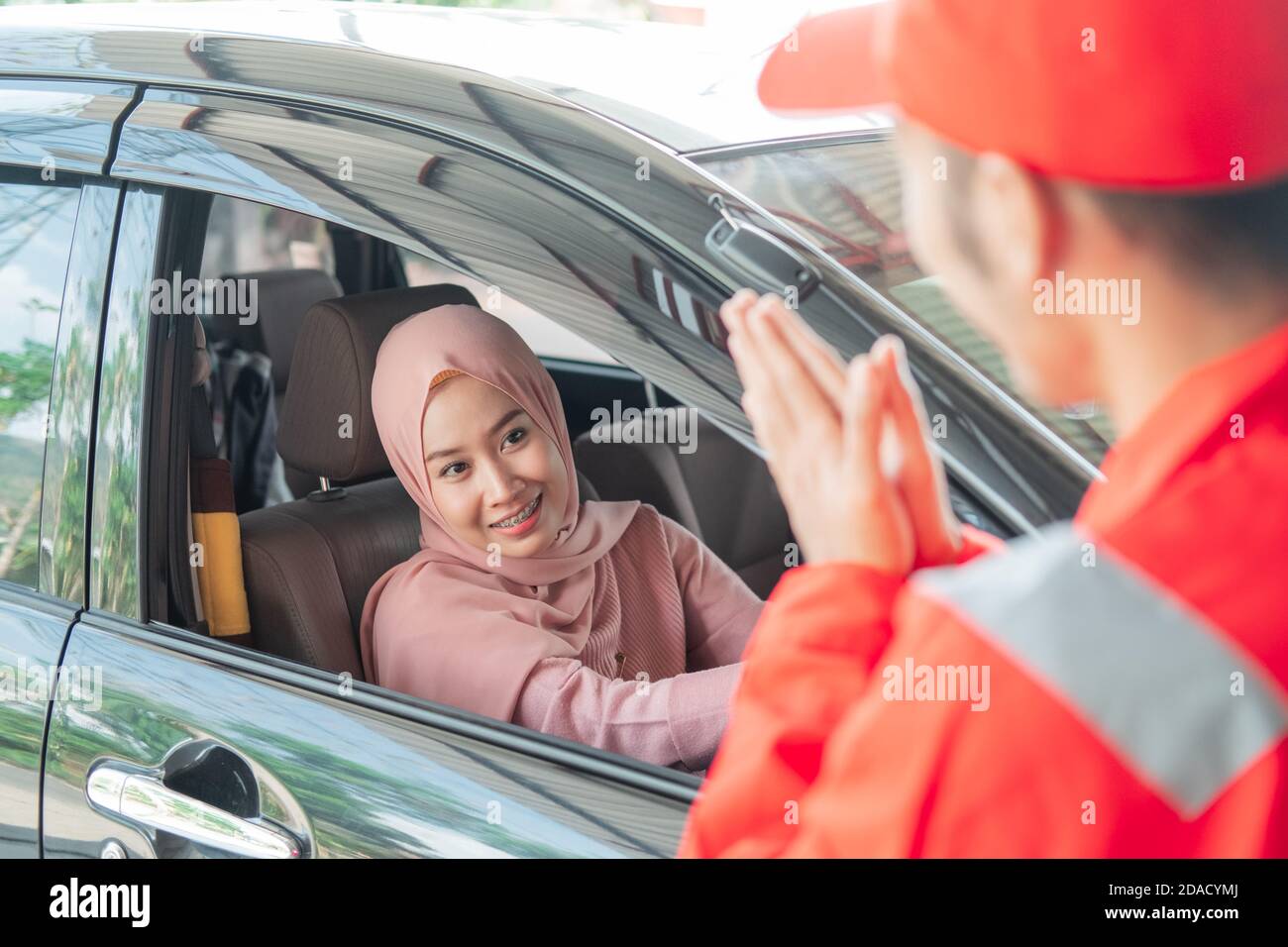 the mechanic wearing the red uniform with a gesture to thank him after ...