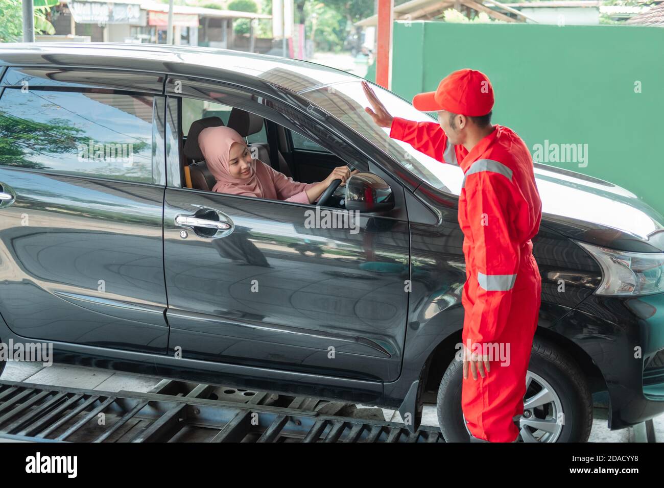 the mechanic wearing the red uniform with a gesture to thank the ...