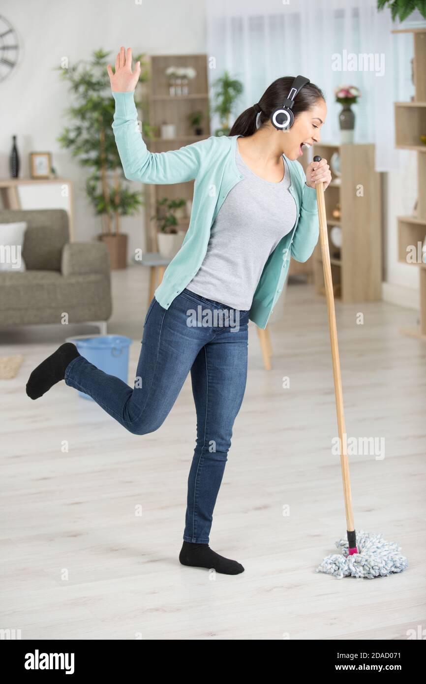 female housekeeper dancing with mop while doing housework Stock Photo ...