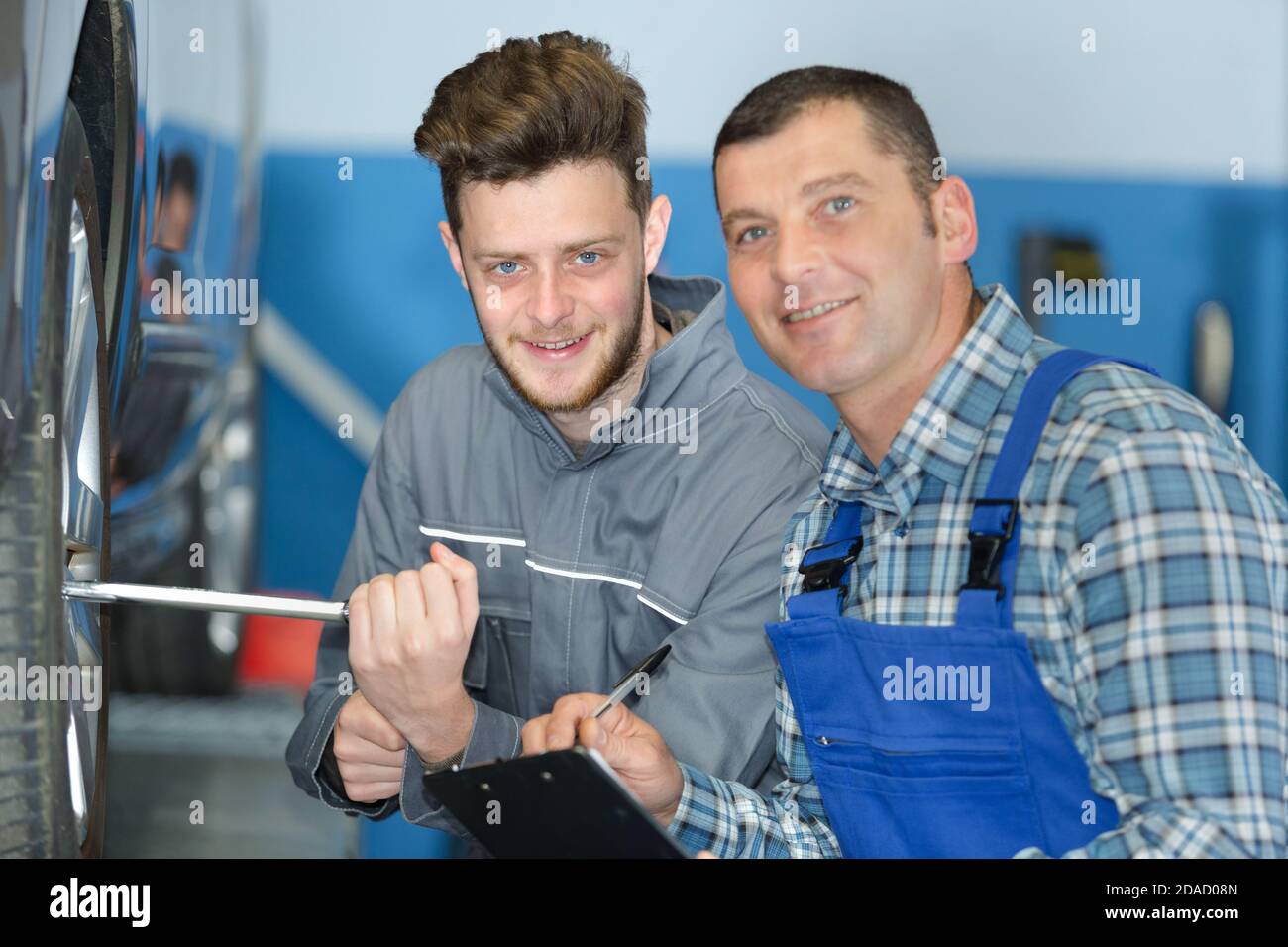 mechanic teaching an intern in a garage Stock Photo - Alamy