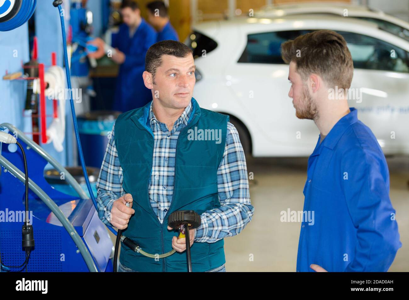 portrait of two happy mechanics talking Stock Photo - Alamy