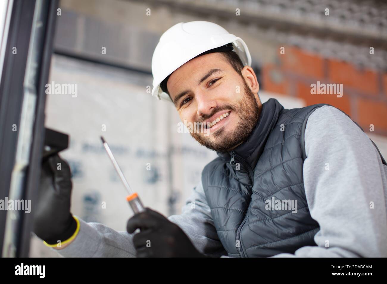 handyman using a cordless screwdriver to install a window handle Stock ...