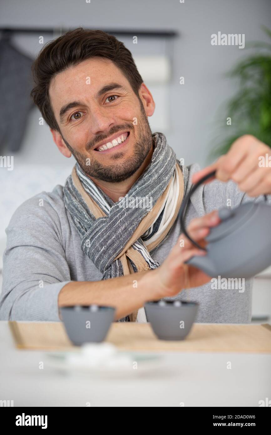 young elegant gentleman pouring tea in cup Stock Photo - Alamy