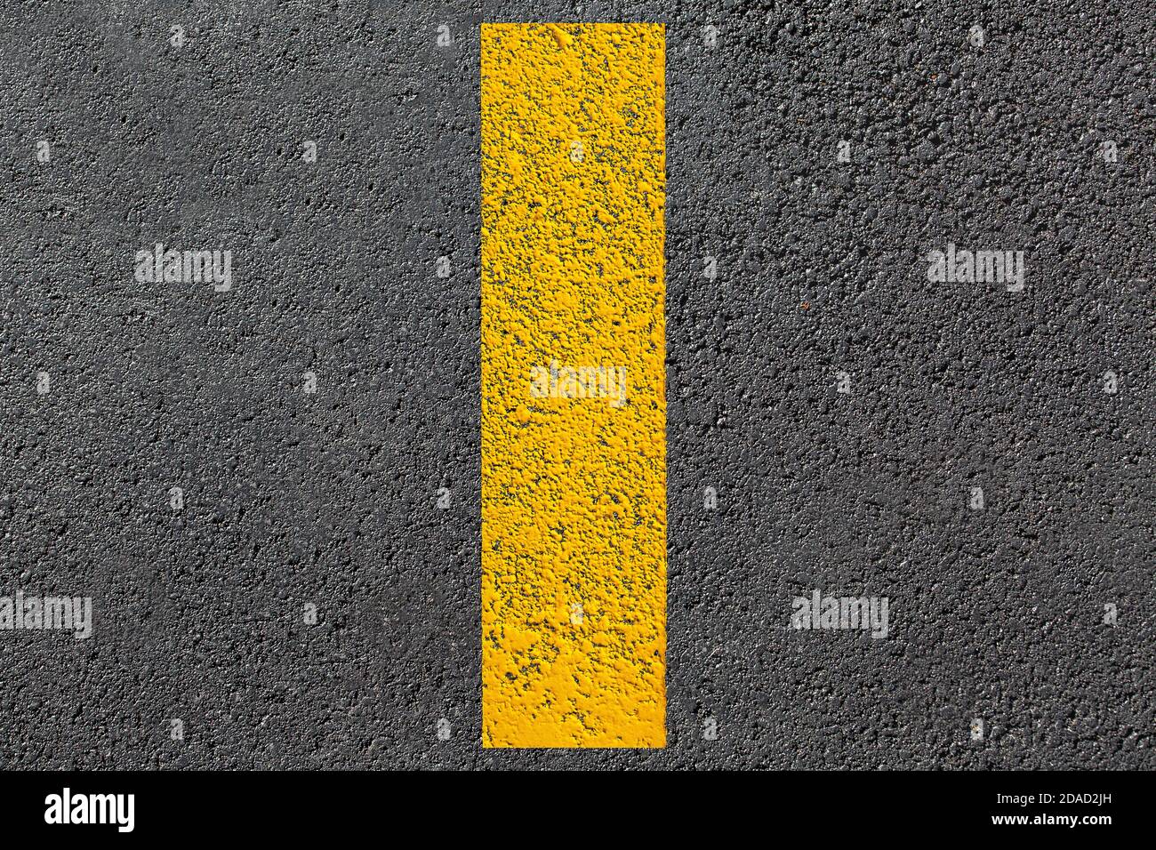 yellow dashed line of road markings close-up on the new bituminous ...