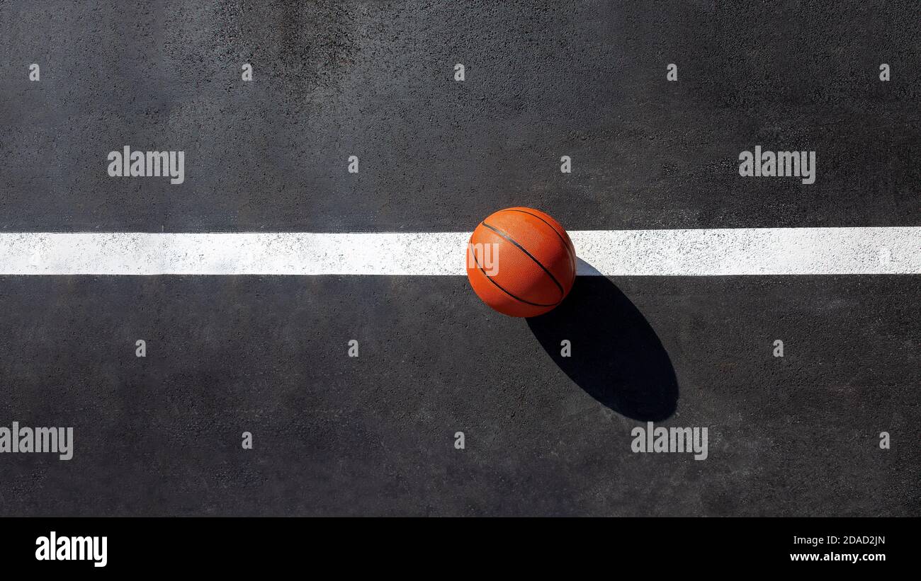 orange striped basketball ball stands on the white line marking the ...