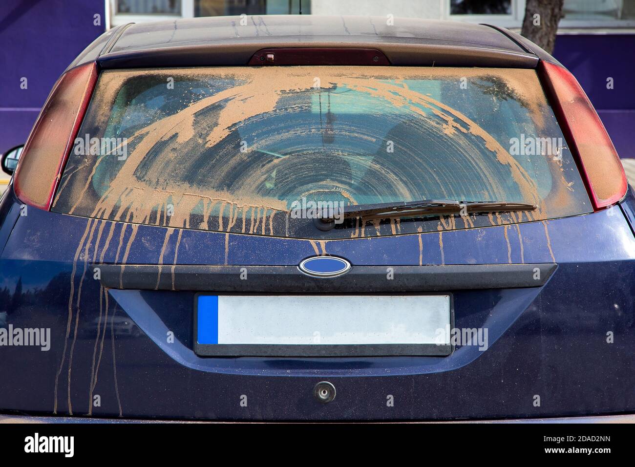 dirty car crossover covered with a dry layer of dust from clay smeared ...