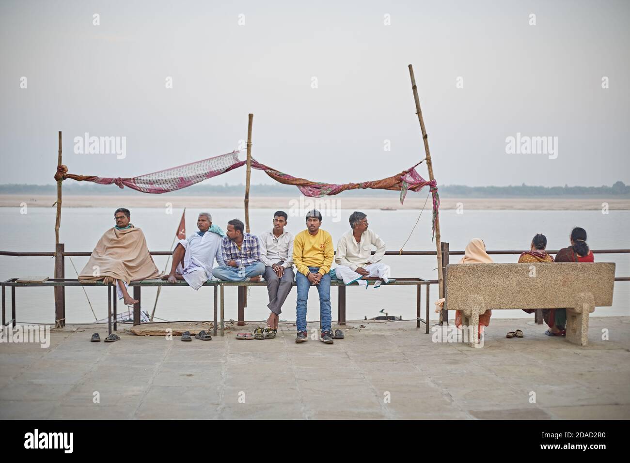 Varanasi, India, November 2015. Several people sitting in a ghat on the ...