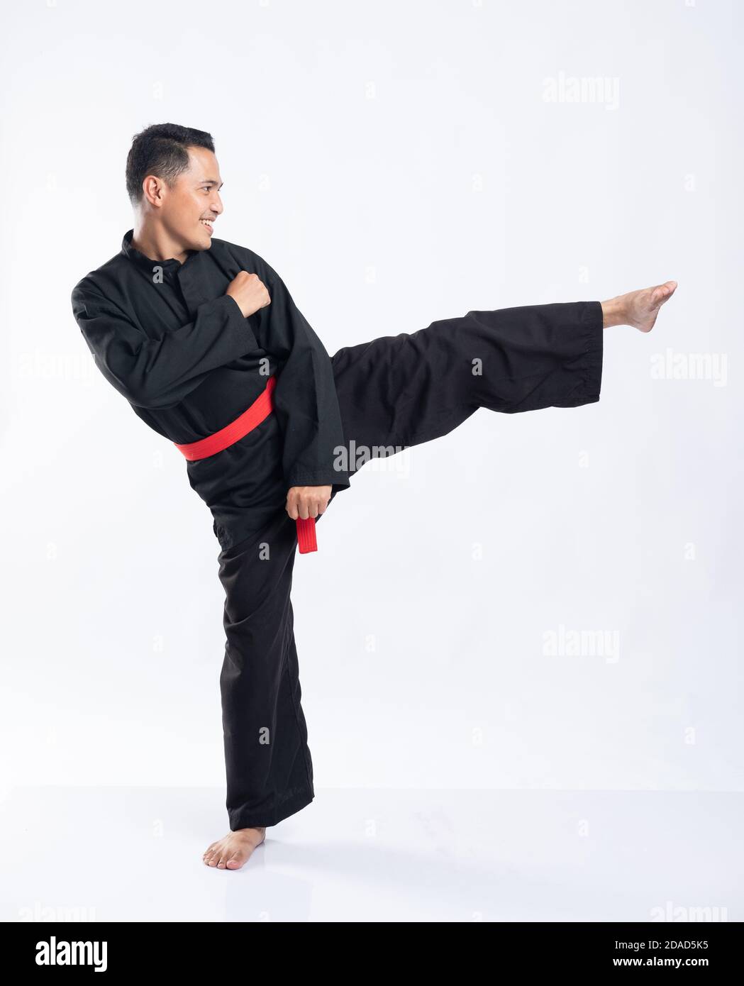 a man wearing a pencak silat uniform with a red belt performed a ...