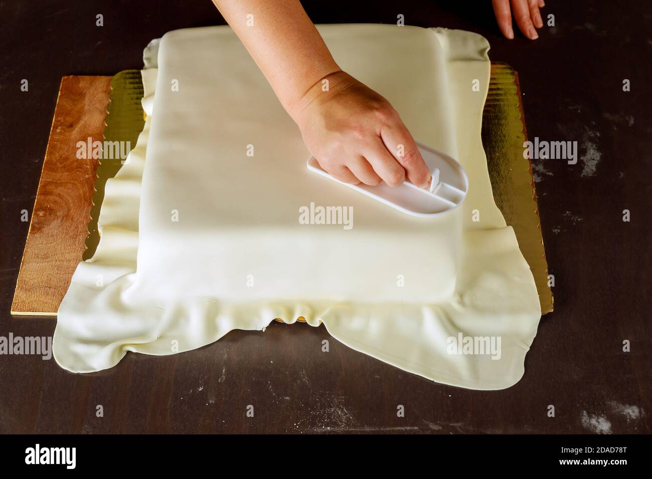 Professional baker cover cake with fondant smoother. Making birthday ...