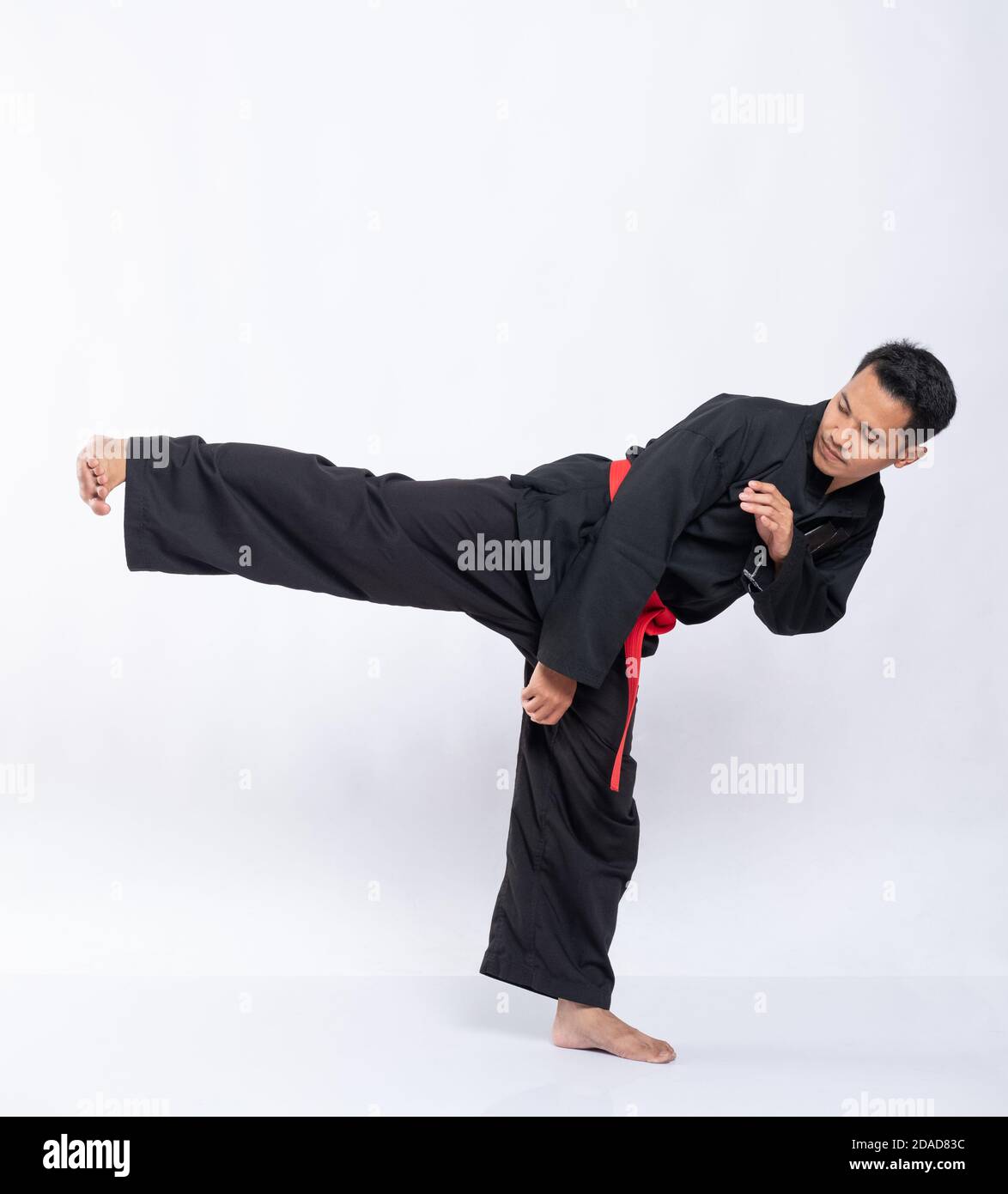 Asian boy with a kicking motion while wearing a pencak silat uniform on ...