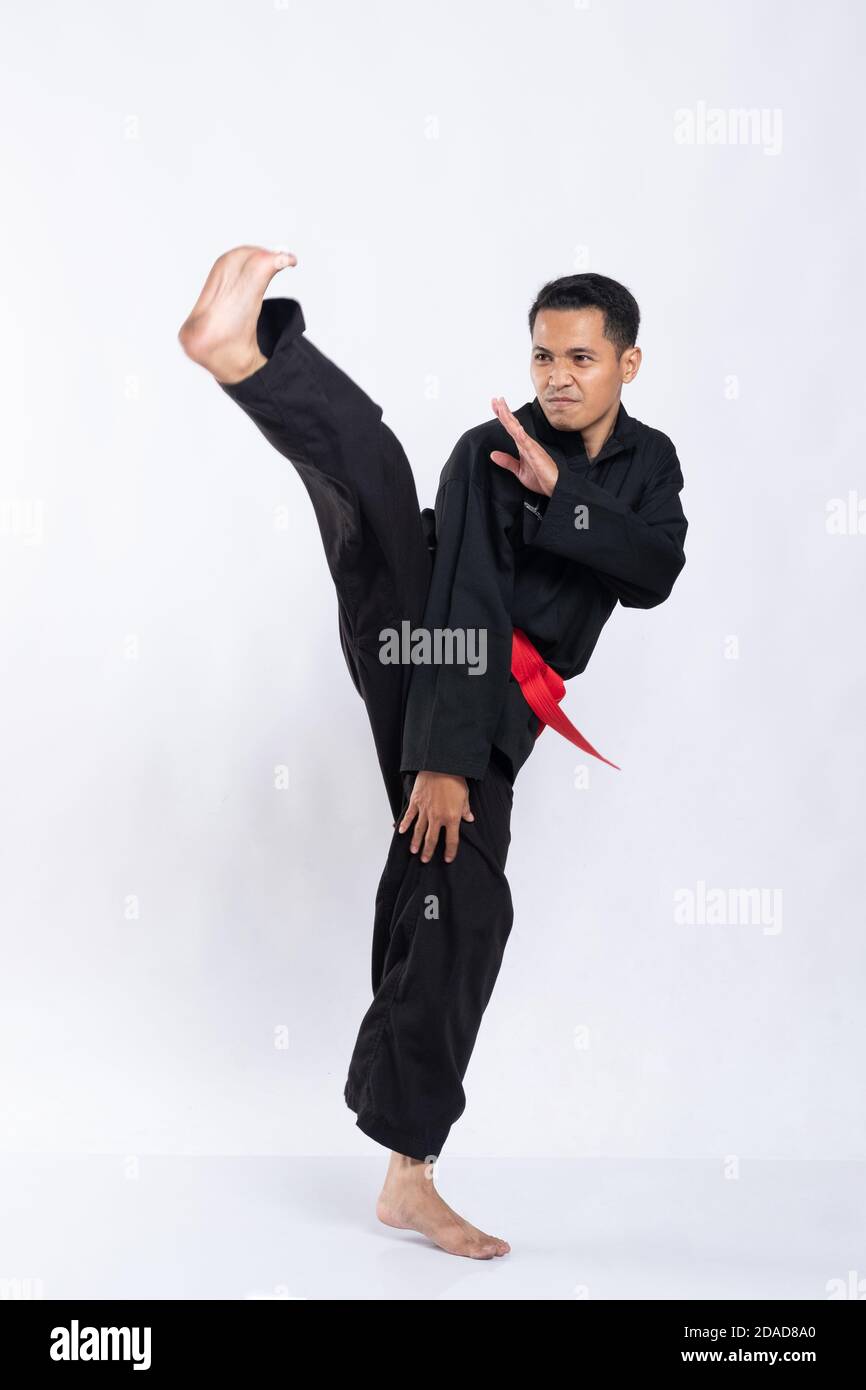 man in pencak silat uniform poses forward kick movement on isolated ...