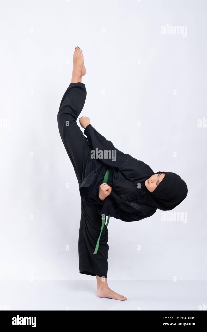 woman in hijab in pencak silat uniform poses a straight upward circular ...