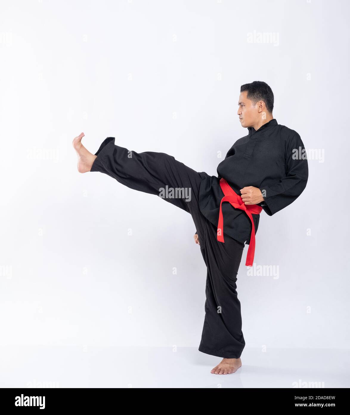 view side of an Asian man with an attacking pose kicking forward while ...