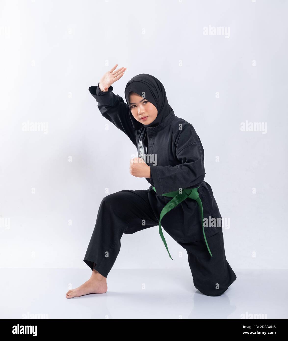Asian women in headscarves wear pencak silat uniforms with squat green ...