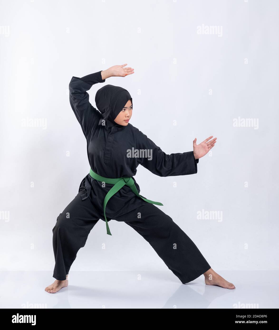 Asian women in hijabs wearing pencak silat uniforms with green belts ...