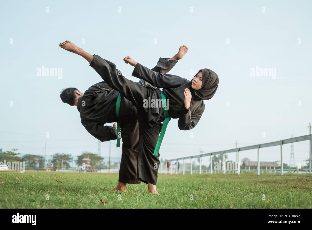 Asian male and female fighters wearing pencak silat uniforms face each ...