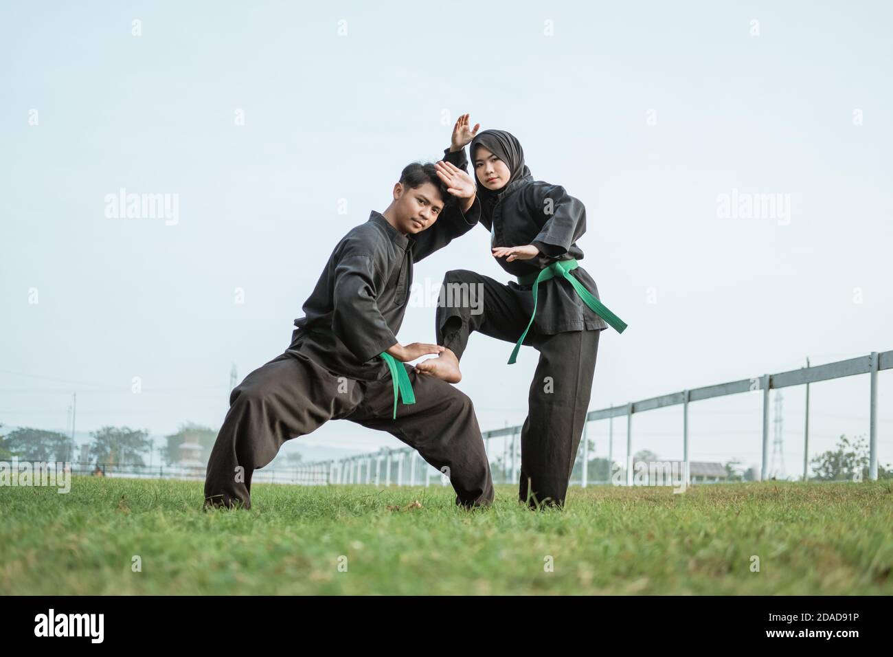 Asian male fighter wearing a pencak silat uniform with low stance pose ...