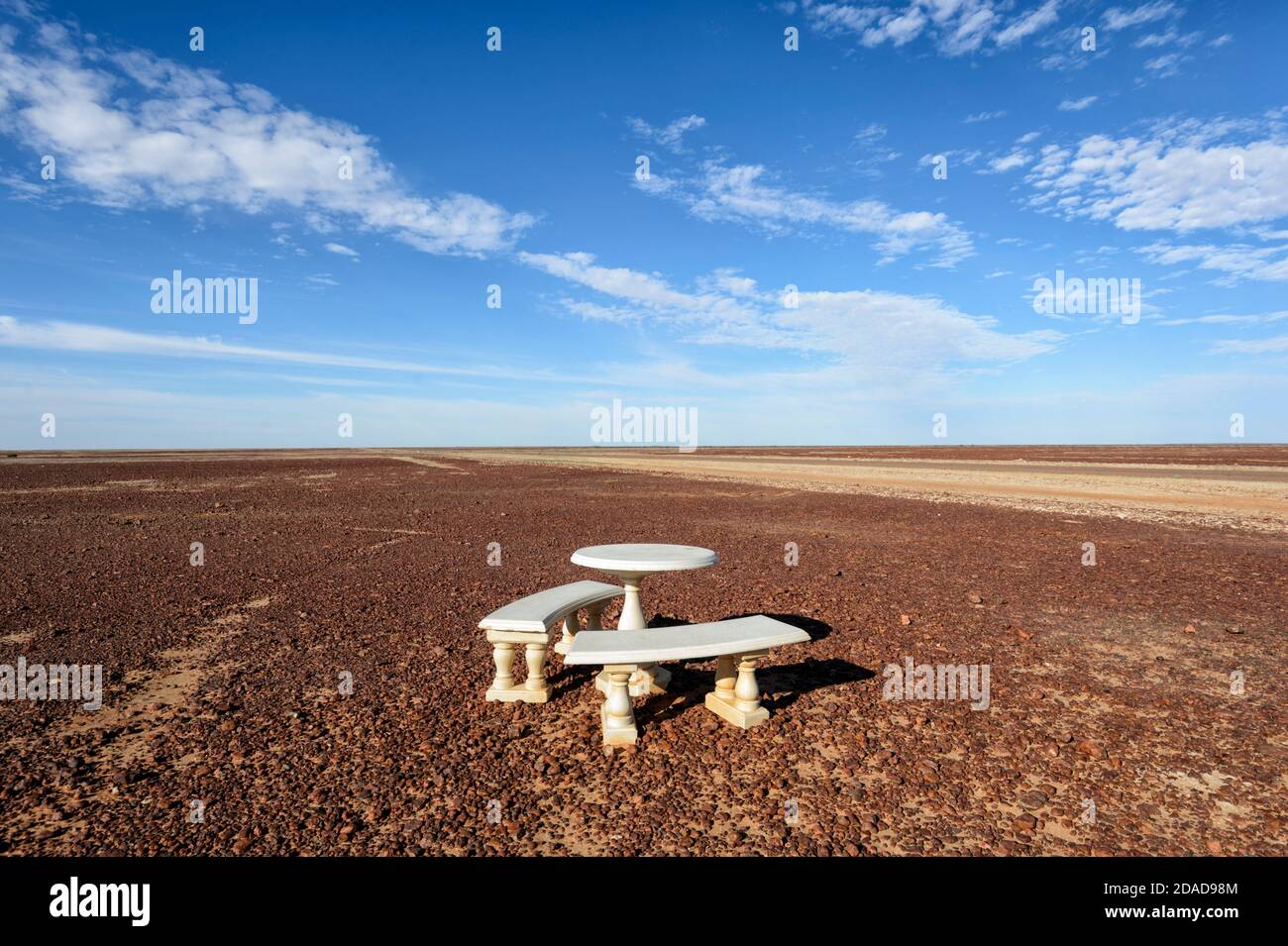 Humorous arrangement of a table and benches in the desert along the ...