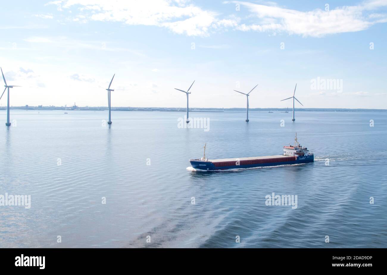 Container ship passing wind turbines in sea Stock Photo - Alamy