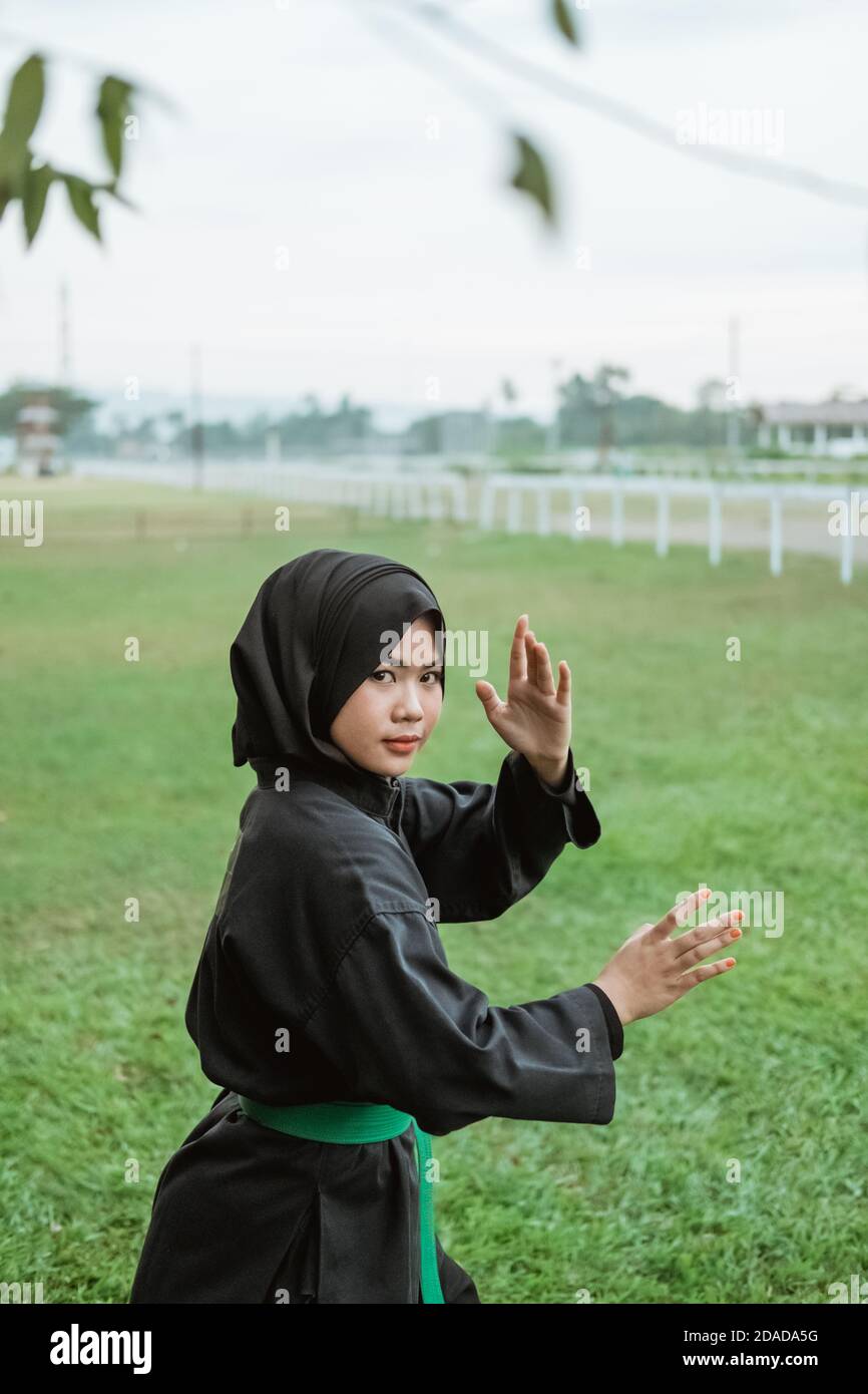 Close up of an Asian veiled woman wearing a pencak silat uniform with a ...