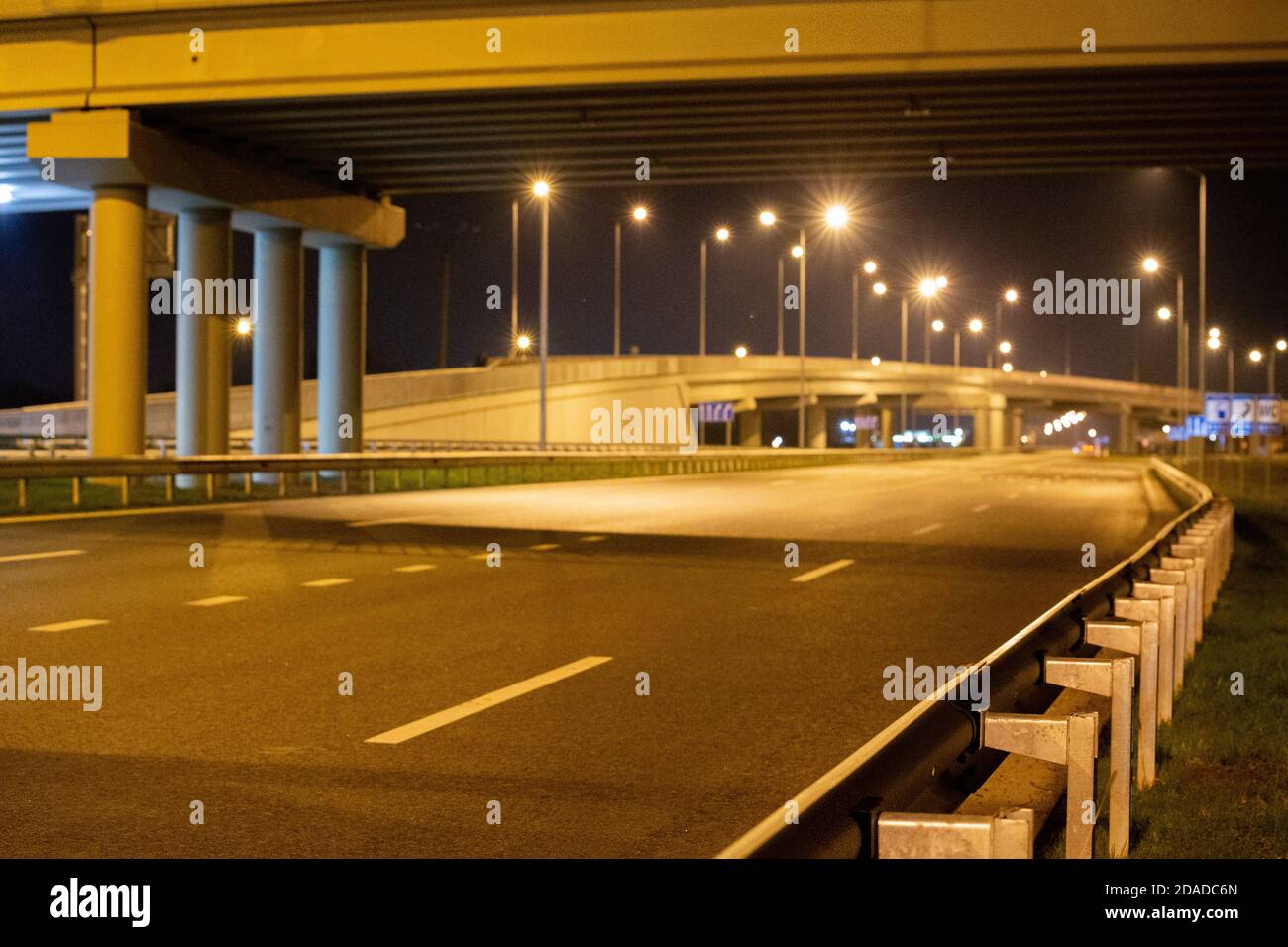 An empty night street lit by lanterns, some city lights in the distance ...