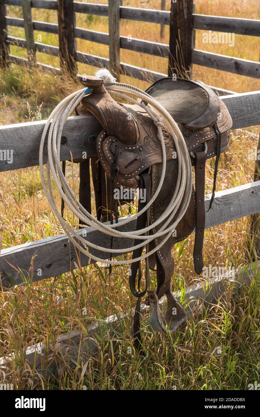 An old tooled-leather western riding saddle on a ranch fence in Idaho ...