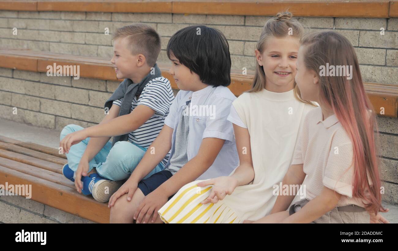 Four girls sitting on the bench hi-res stock photography and images - Alamy