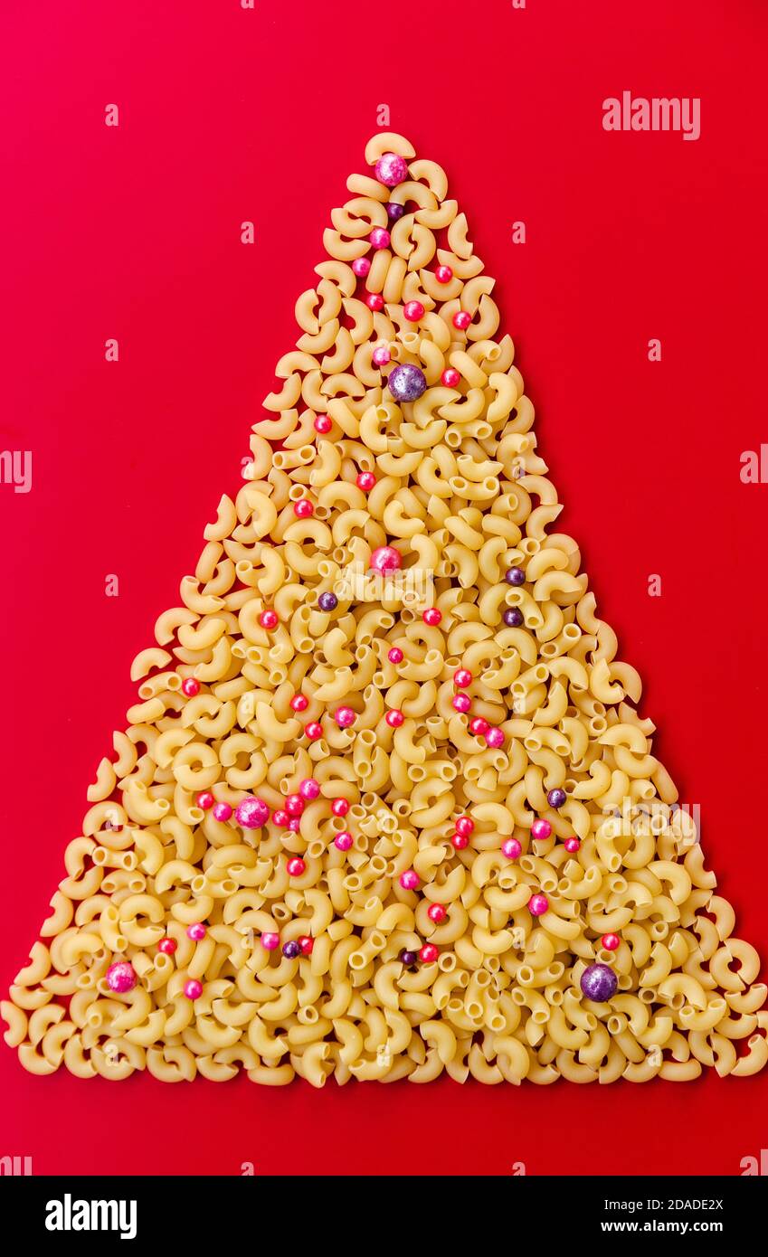 Christmas tree of pasta decorated with balls on a red background Stock ...