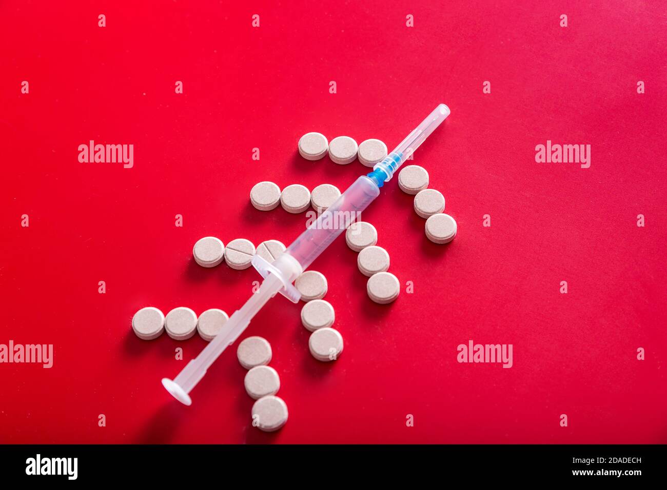 Syringe and pills in the shape of a Christmas tree on a red background ...