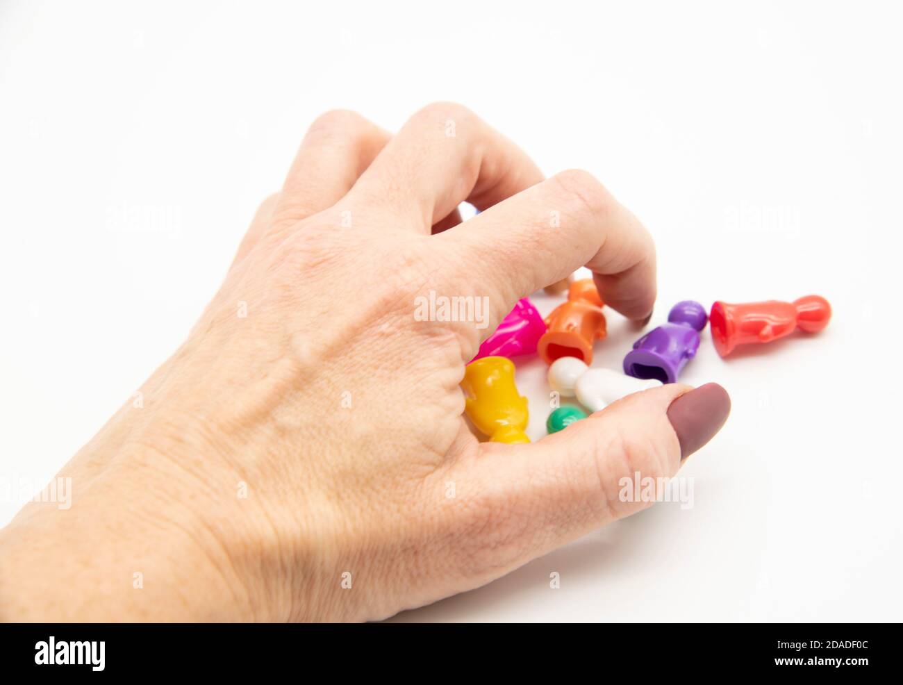 Women's hand with a manicure rakes in a bunch of little plastic ...