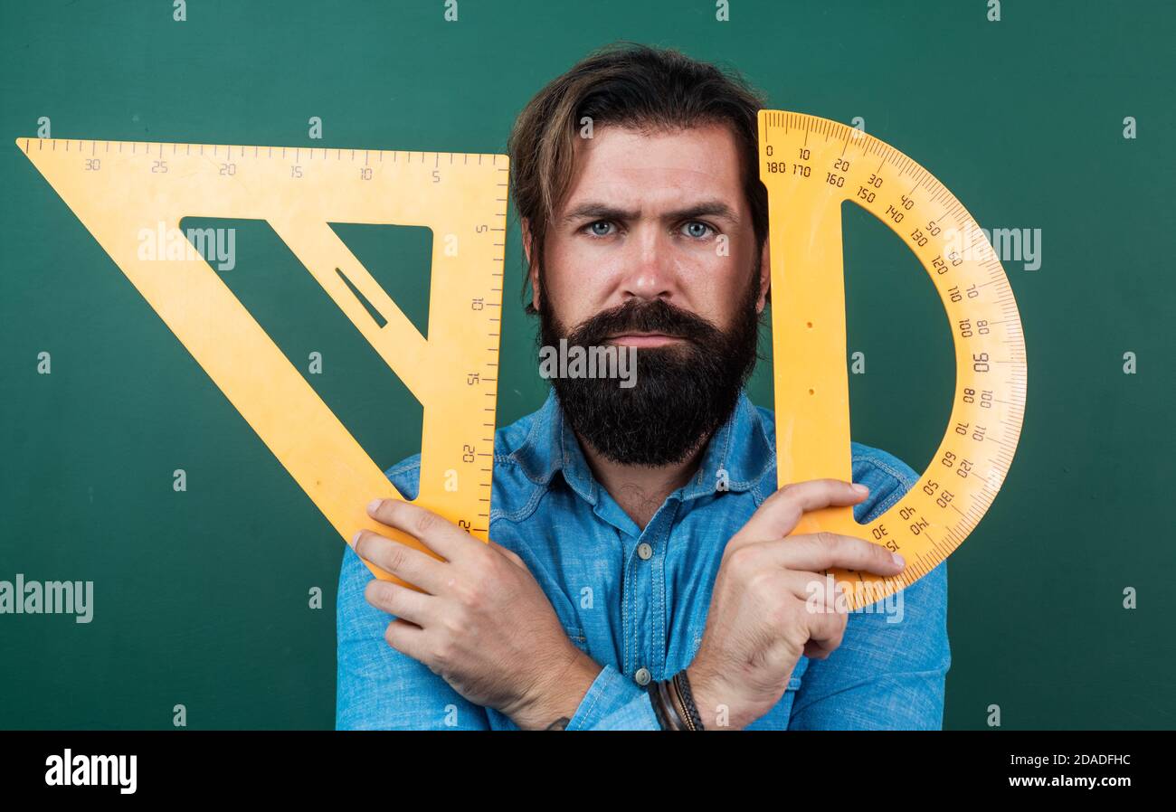 formal education. measure and size. serious teacher hold triangle and ...