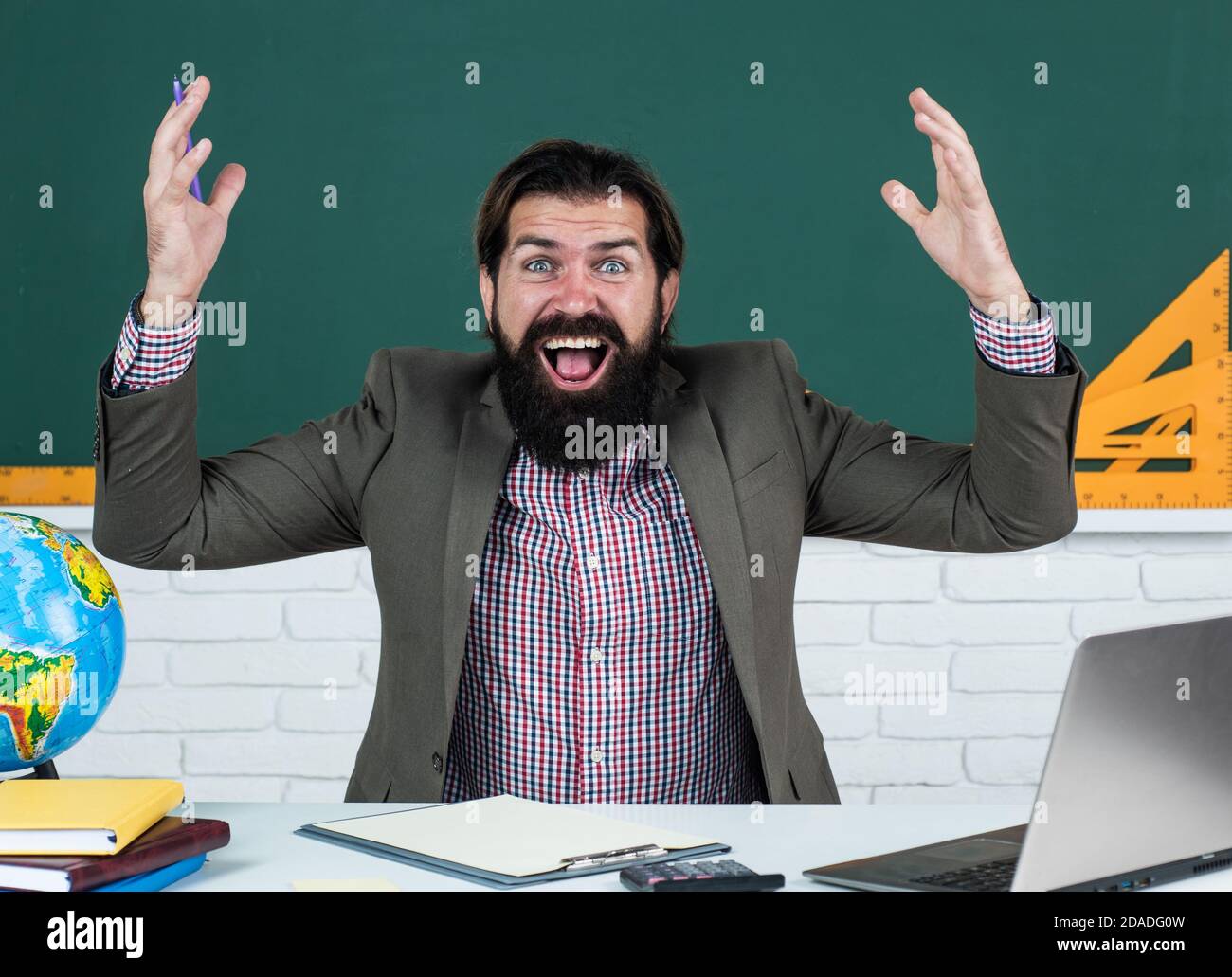 angry male teacher with laptop in classroom, education Stock Photo - Alamy