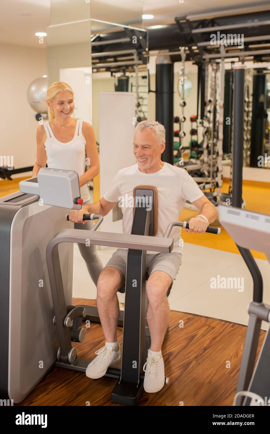 Mature couple exercising together in the gym and looking energized ...
