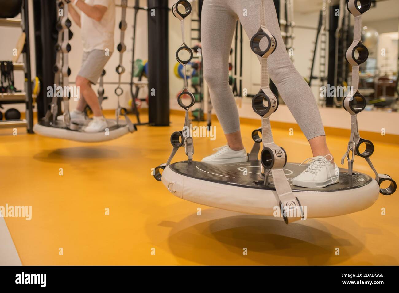 Close up picture of two people exercising on hanging gym maching Stock ...