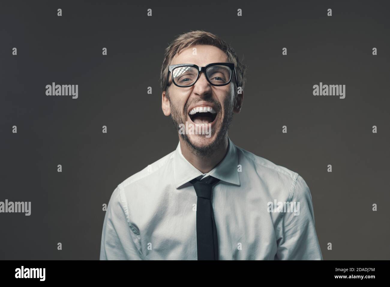Young businessman laughing out loud and staring at camera Stock Photo ...