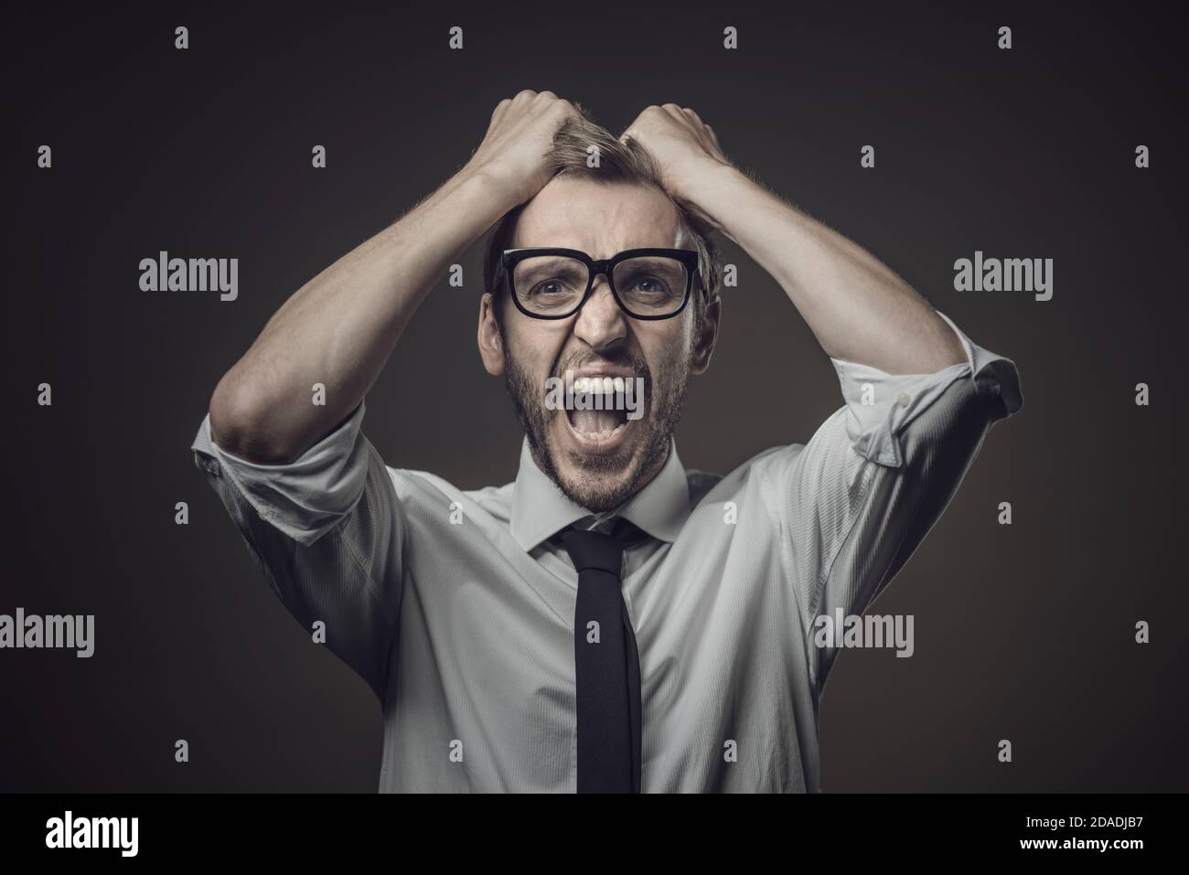 Angry stressed businessman with head in hands, he is shouting and ...