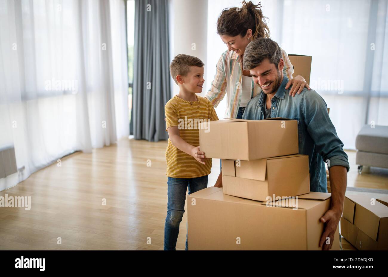 Family unpacking cardboard boxes at new home Stock Photo - Alamy