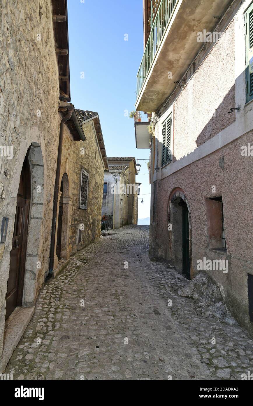 A narrow street among the old houses of Fumone, a medieval village in ...