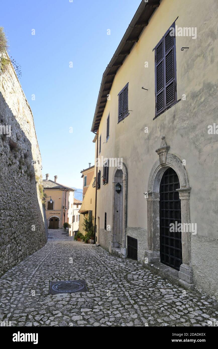A narrow street among the old houses of Fumone, a medieval village in ...
