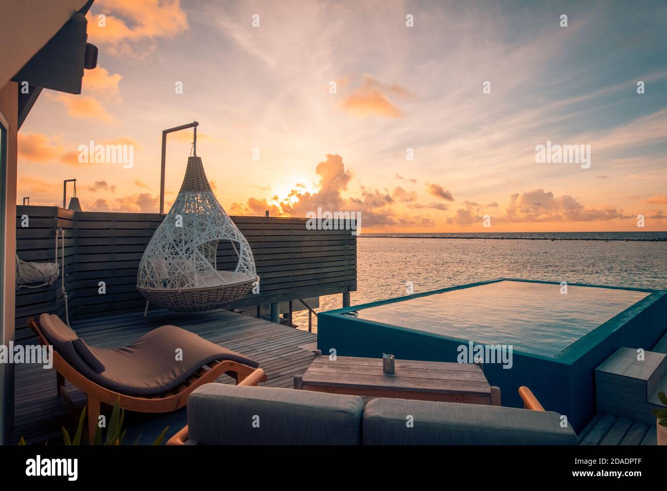 Luxury resort, seascape, sunset sky and infinity pool on terrace. Sun ...
