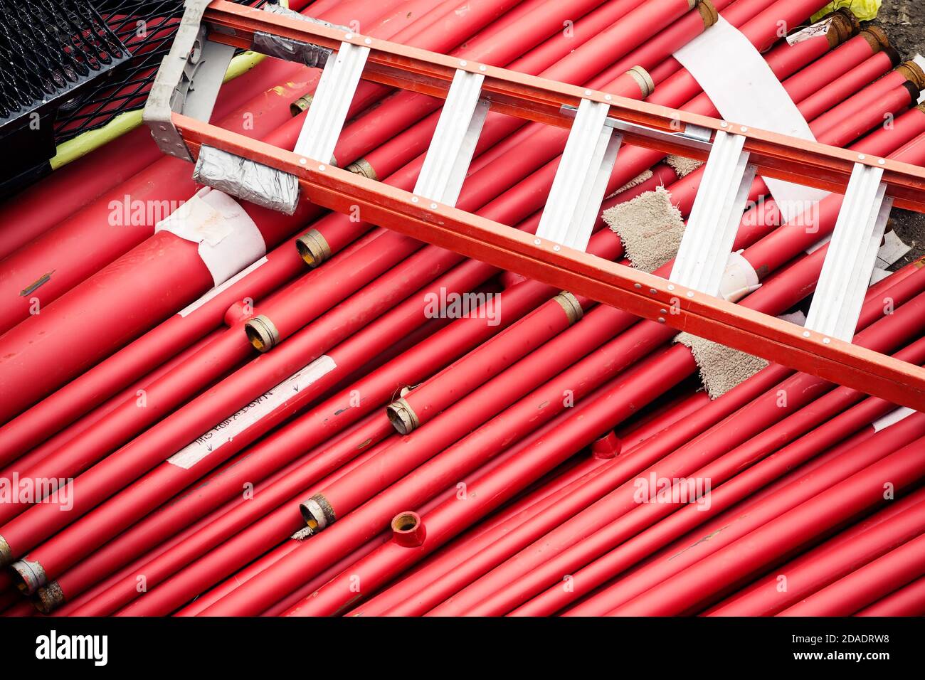 Red metal pipes stacked for working at construction site Stock Photo ...