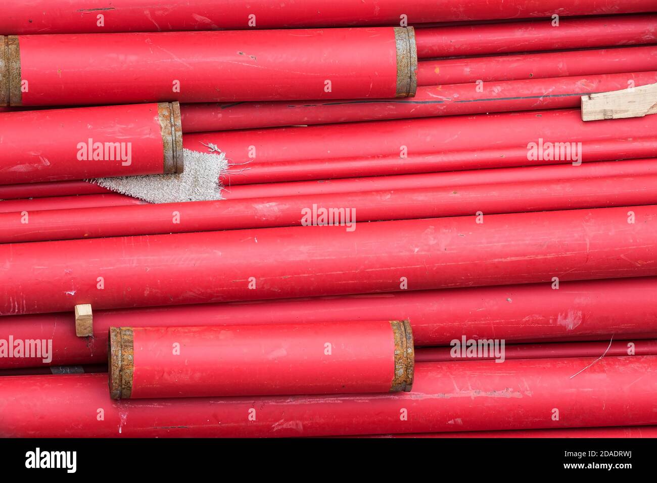 Red metal pipes stacked for working at construction site Stock Photo ...