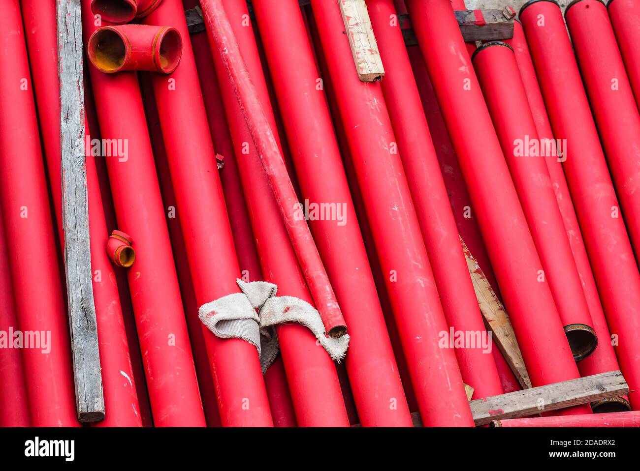 Red metal pipes stacked for working at construction site Stock Photo ...