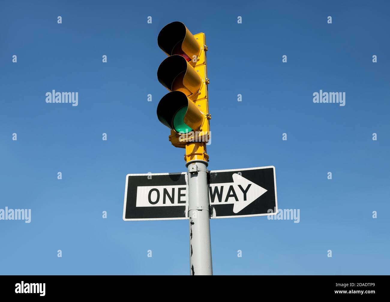 Crosswalk in New York City. Traffic light and One Way road sign against ...